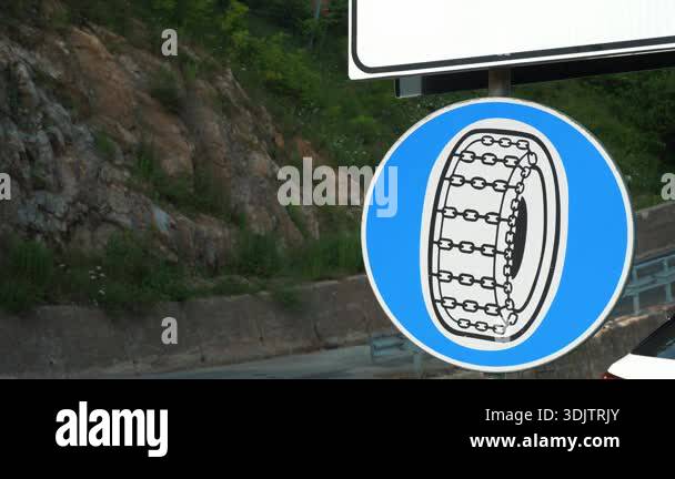 Blue round road sign for mandatory anti-slip snow chains. Close-up shot ...
