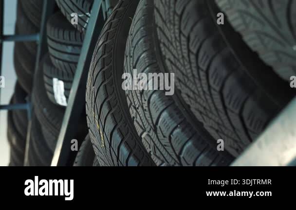 Close up of new car tire treads stacked neatly on racks in auto repair ...