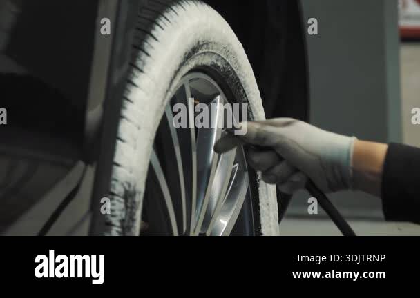 Pumping up car tire pressure close up using air hose in service ...