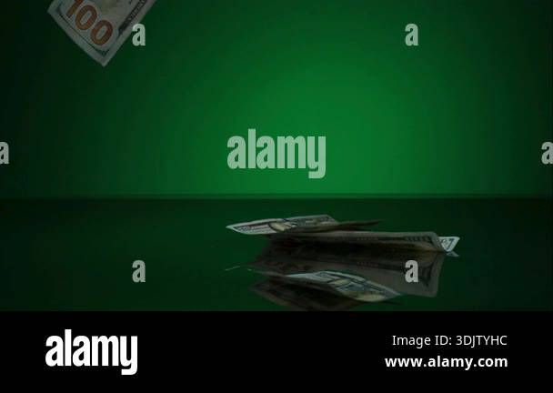 Pile of one hundred dollar bills falling down on a dark green ...