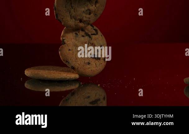 Delicious chocolate chip cookies falling and bouncing on a dark mirror ...