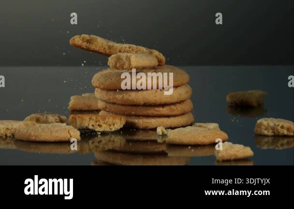 Stack of round sugar cookies with one cookie falling on top and ...