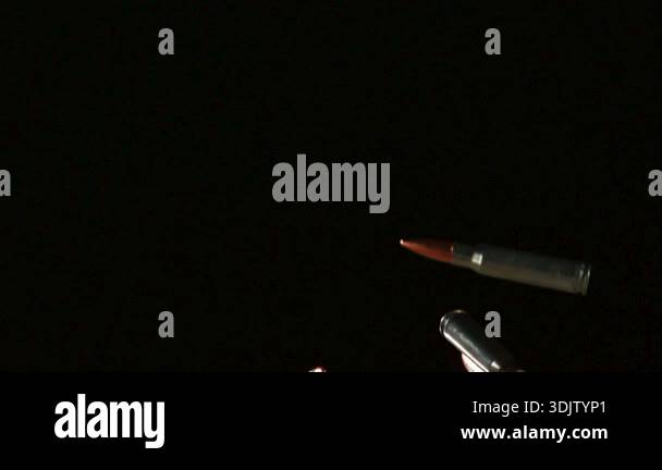Multiple silver rifle bullets and brass ammunition casings falling and ...