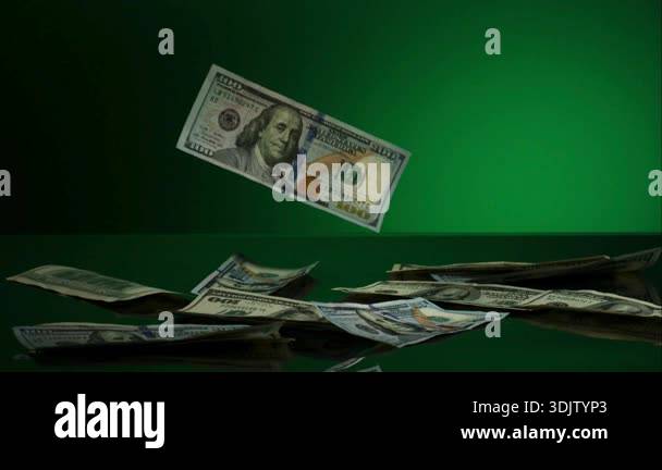 One hundred dollar bills falling and scattering onto a dark reflective ...