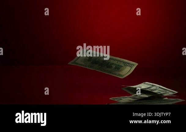 Stack of American one hundred dollar bills falling onto a dark ...