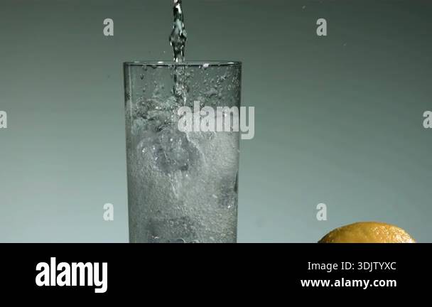Extreme close up of sparkling carbonated water pouring into a tall ...