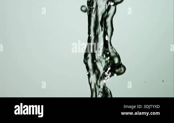 Vertical stream of clear transparent water falling down and breaking ...
