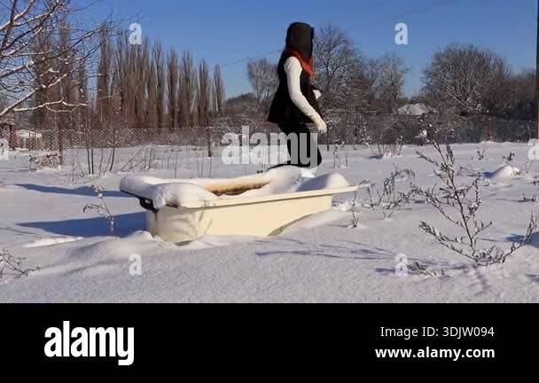 A beautiful girl with a diary in her hands near an old bathtub in the ...