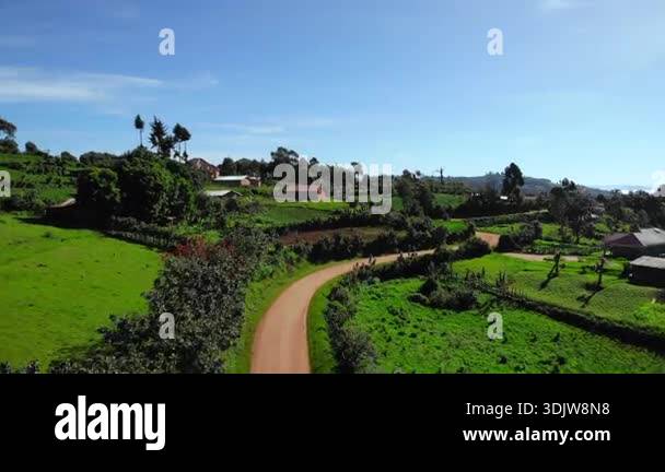 Aerial Winding Dirt Road Through Green Hills And Scattered Village ...