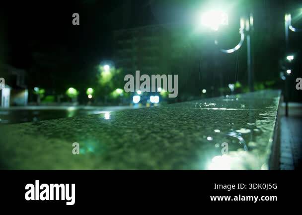 Detailed shot of individual rain drops hitting the surface of water ...