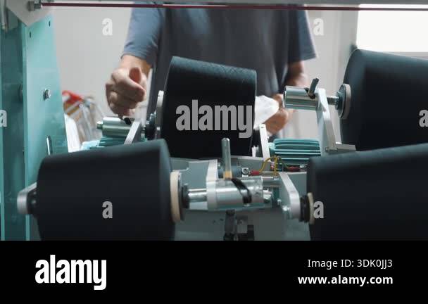 Manual labor and automation combined in a textile factory as a worker ...