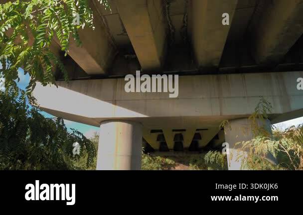 Monumental concrete pillars under a bridge, viewed from below ...