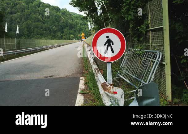 Round road sign prohibiting pedestrian traffic on bridge in mountains ...