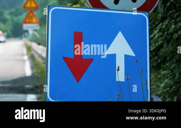 Blue square traffic sign with red and white priority arrows. Close-up ...