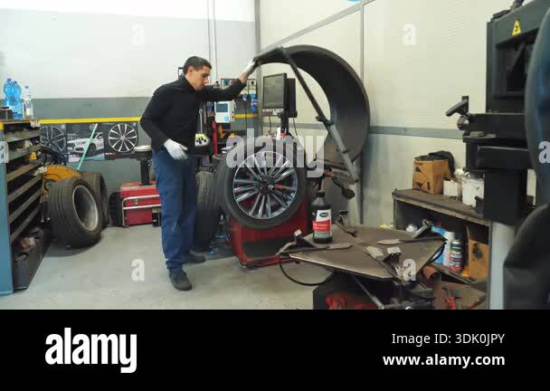 Car wheel spinning on balancing machine at auto workshop. Close up of ...