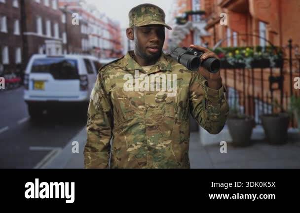 Man soldier in camouflage uniform holding binoculars and pointing ...