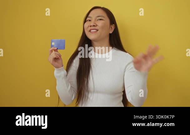 Young chinese woman smiling and gesturing ok sign with credit card on ...