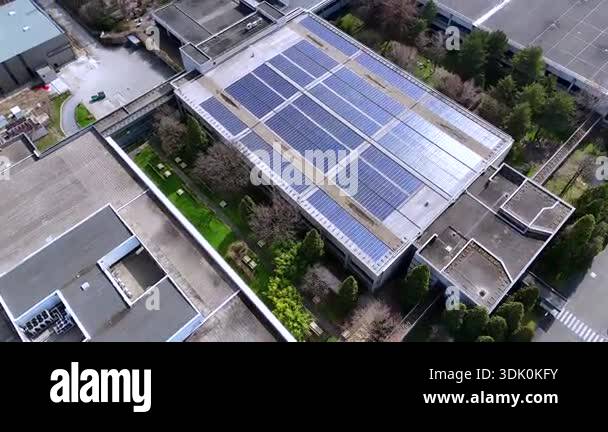 Overhead drone footage of rooftop solar panels among trees and lawns in ...