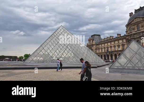 Visitors walking around the iconic Louvre Pyramid Stock Video Footage ...