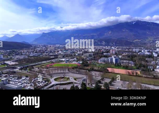 Wide drone panorama of Grenoble France showing city blocks stadium and ...