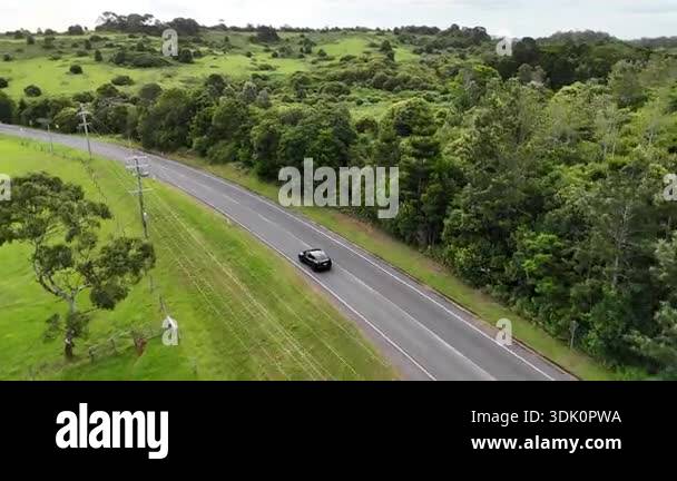 Car travels along lush, winding rural road Stock Video Footage - Alamy