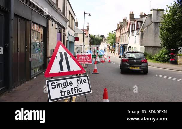 Cars navigate single file traffic in town Stock Video Footage - Alamy