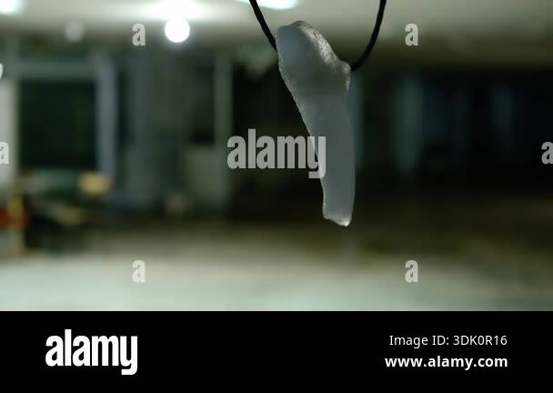 A frozen icicle hangs from a loose cable inside a dark underpass as ...