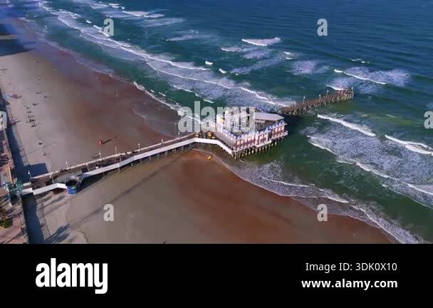 Overhead aerial footage of Daytona Beach Florida coastline with pier ...