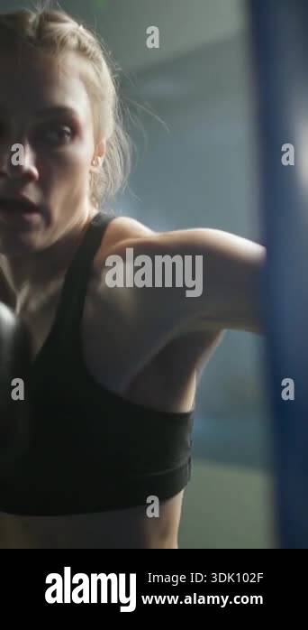 Woman power, fighter beats a punching bag and trains his punches, slow ...