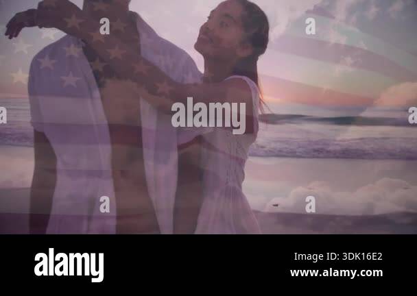 Woman approaching man on beach sunset, embracing under stars stripes ...