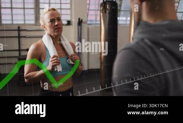 Trainer gesturing toward data overlay in gym, woman reading line graph ...