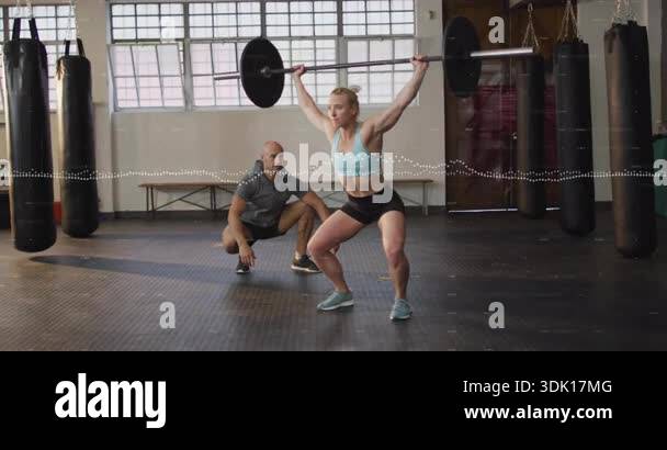 Female athlete bracing core initiating squat in gym for health gain ...