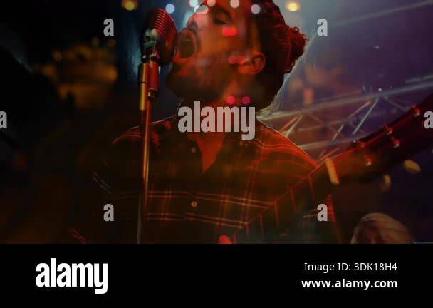 Camera pulling back musician leaning into mic singing and playing ...