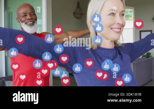 Fitness couple holding arm stretch at home, causing blue thumbs-up and ...