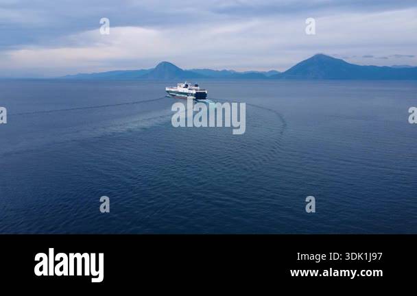 Large passenger ship moves across clear sea leaving intense wake and ...