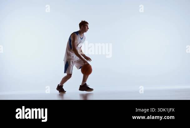 Basketball athlete catching and bouncing ball during focused training ...