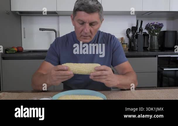 A man sits at his kitchen table, curiously examining a freshly cooked ...
