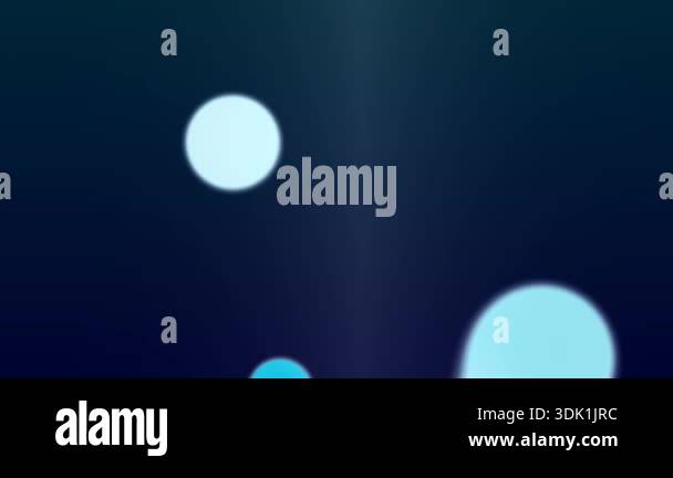 Abstract blue bokeh lights drift across a dark background creating a ...