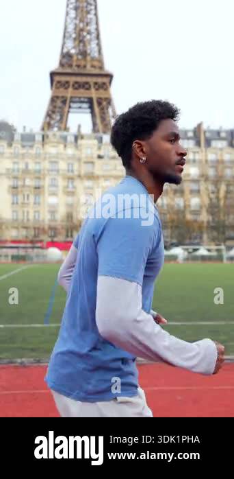 Side view of a determined young black man running on a red track during ...