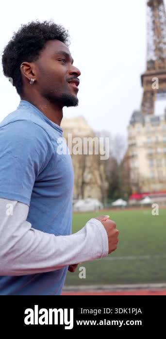 Athletic african american man jogging on a running track with the ...