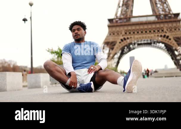 Young athletic man warming up and stretching his leg muscles before a ...