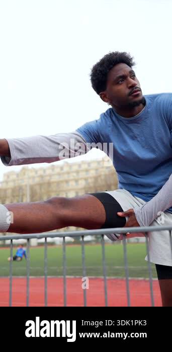 Focused african american athlete stretching hamstring on a metal ...