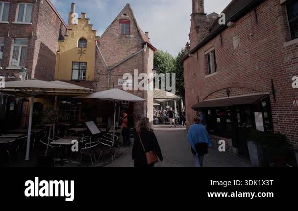 BRUGES, BELGIUM - SEPTEMBER 15, 2025 - Tourists walk through a narrow ...