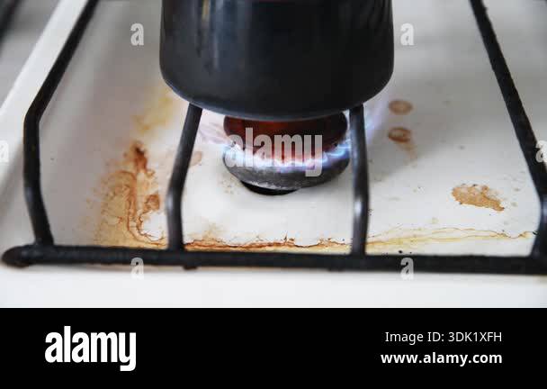 Rust-stained white cooktop with black grill grate showing worn, dirty ...