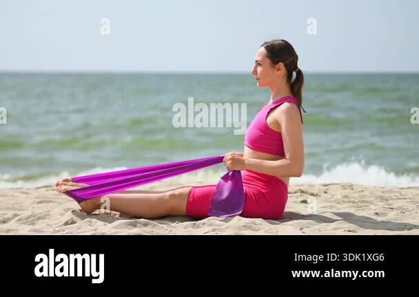 Athletic young woman with dark hair in ponytail wearing pink workout ...