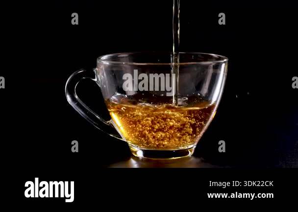 A sequence showing tea being poured into a clear glass cup against a ...