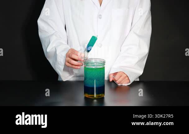 A scientist uses a syringe to create a lava lamp effect in a jar ...