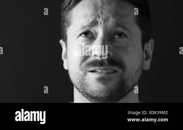 Sad man crying on dark background, closeup. Black and white effect ...