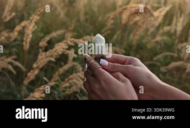 Woman meditating with crystal to heal or restore her aura outdoors ...