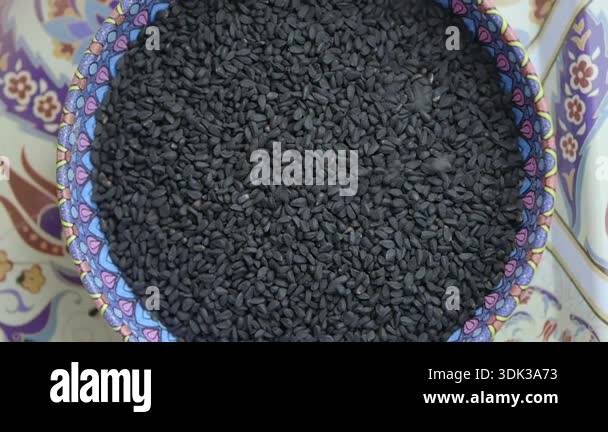 Black cumin seeds in bowl on colorful table Stock Video Footage - Alamy